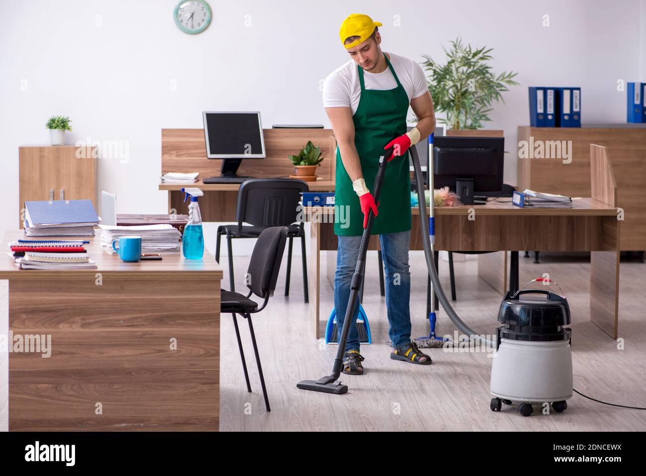 Young contractor cleaning the office Stock Photo - Alamy