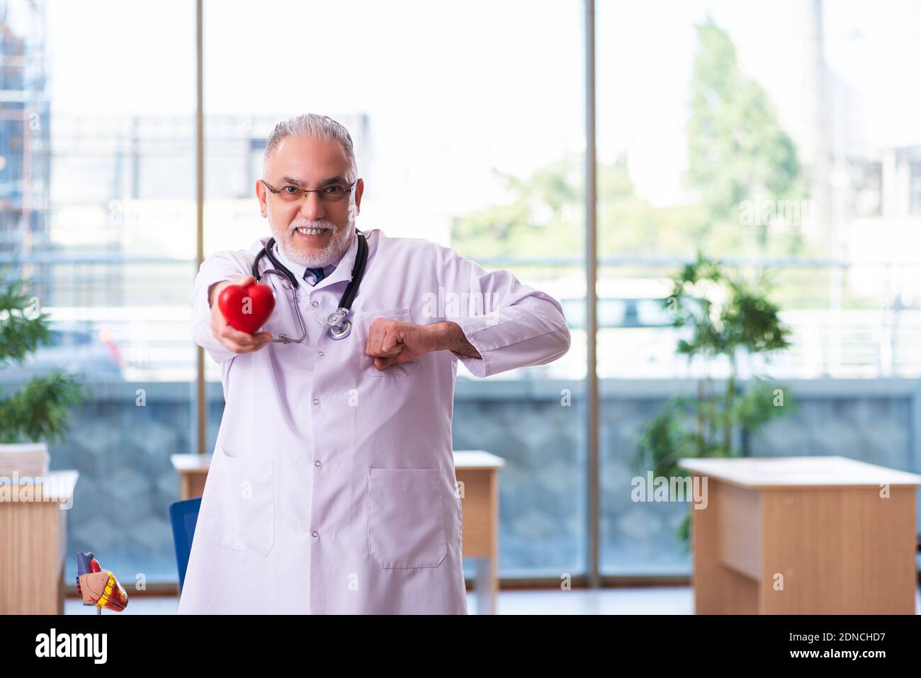 Old doctor cardiologist working in the clinic Stock Photo - Alamy
