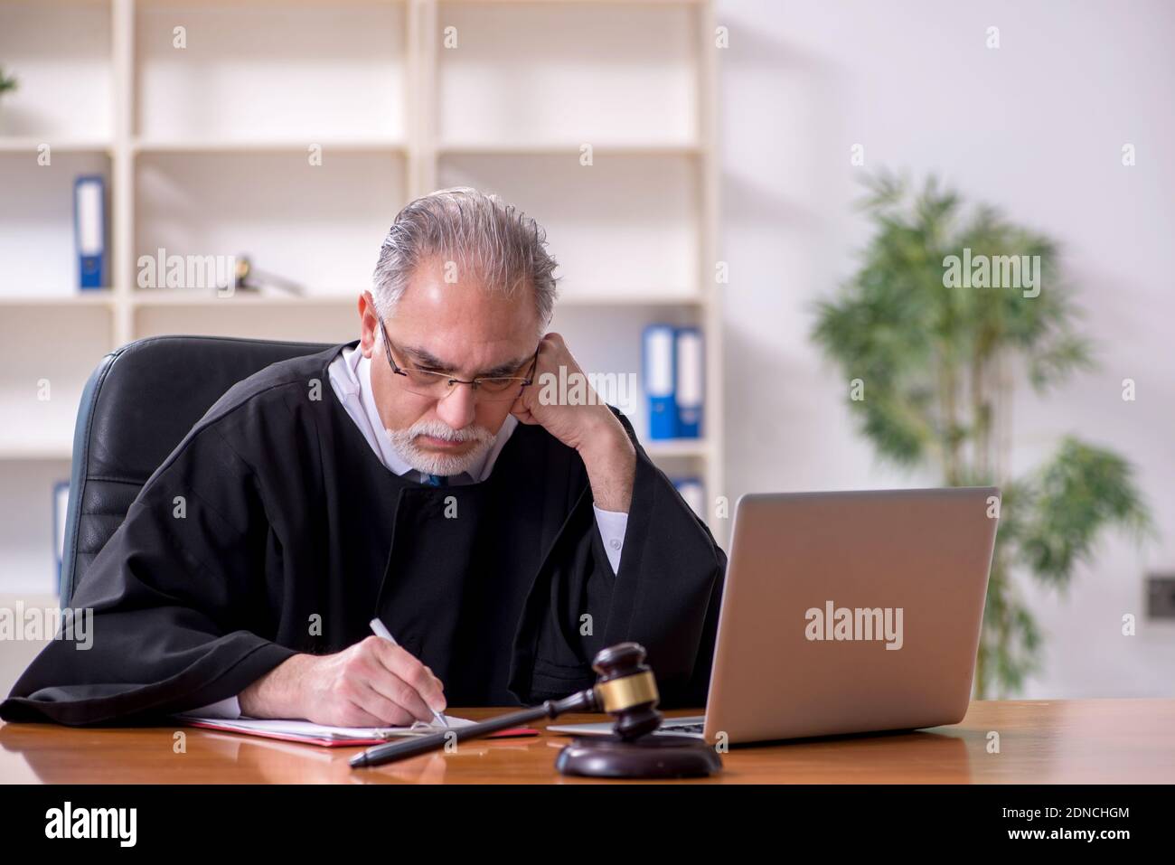 Old male judge working in the courthouse Stock Photo - Alamy