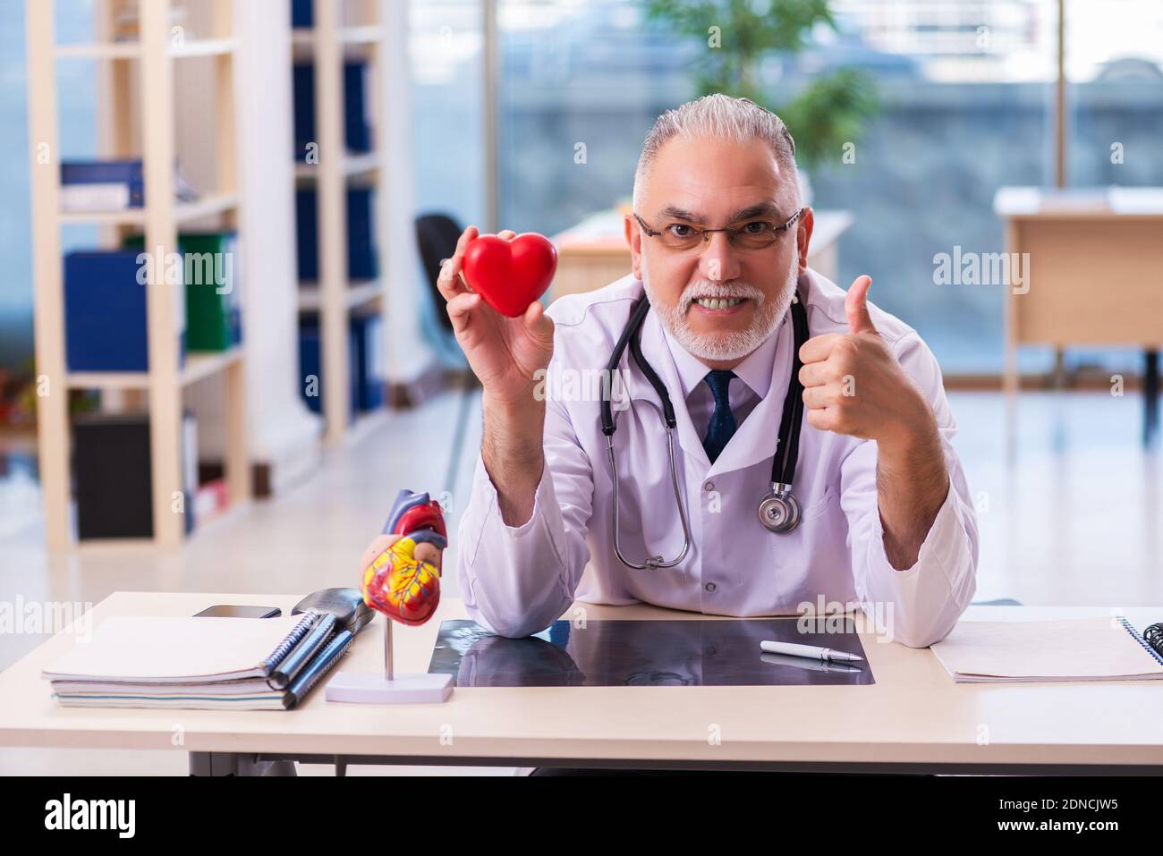 Old doctor cardiologist working in the clinic Stock Photo - Alamy