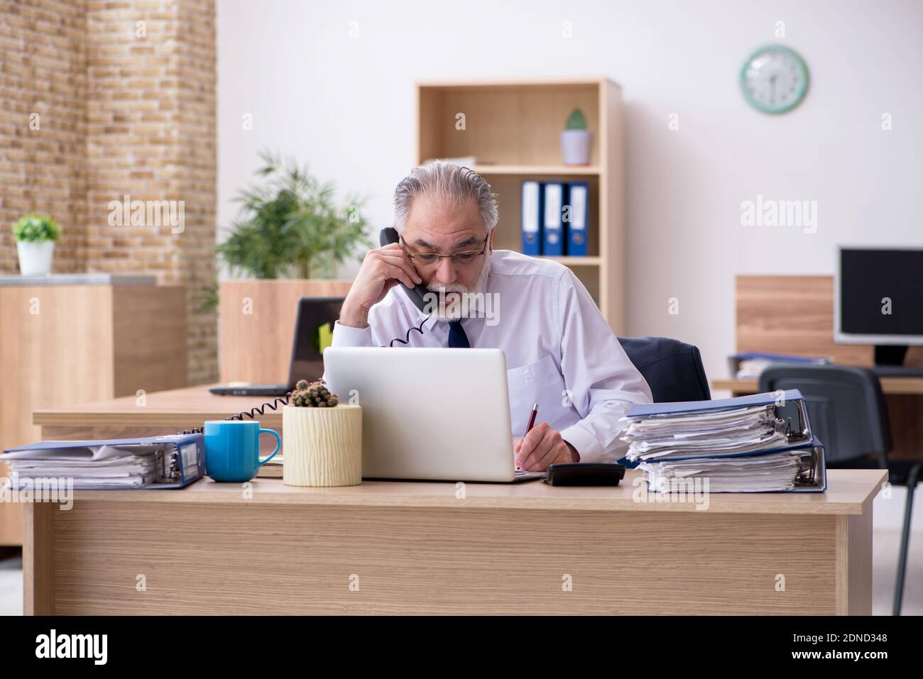 Old employee working in the office Stock Photo - Alamy