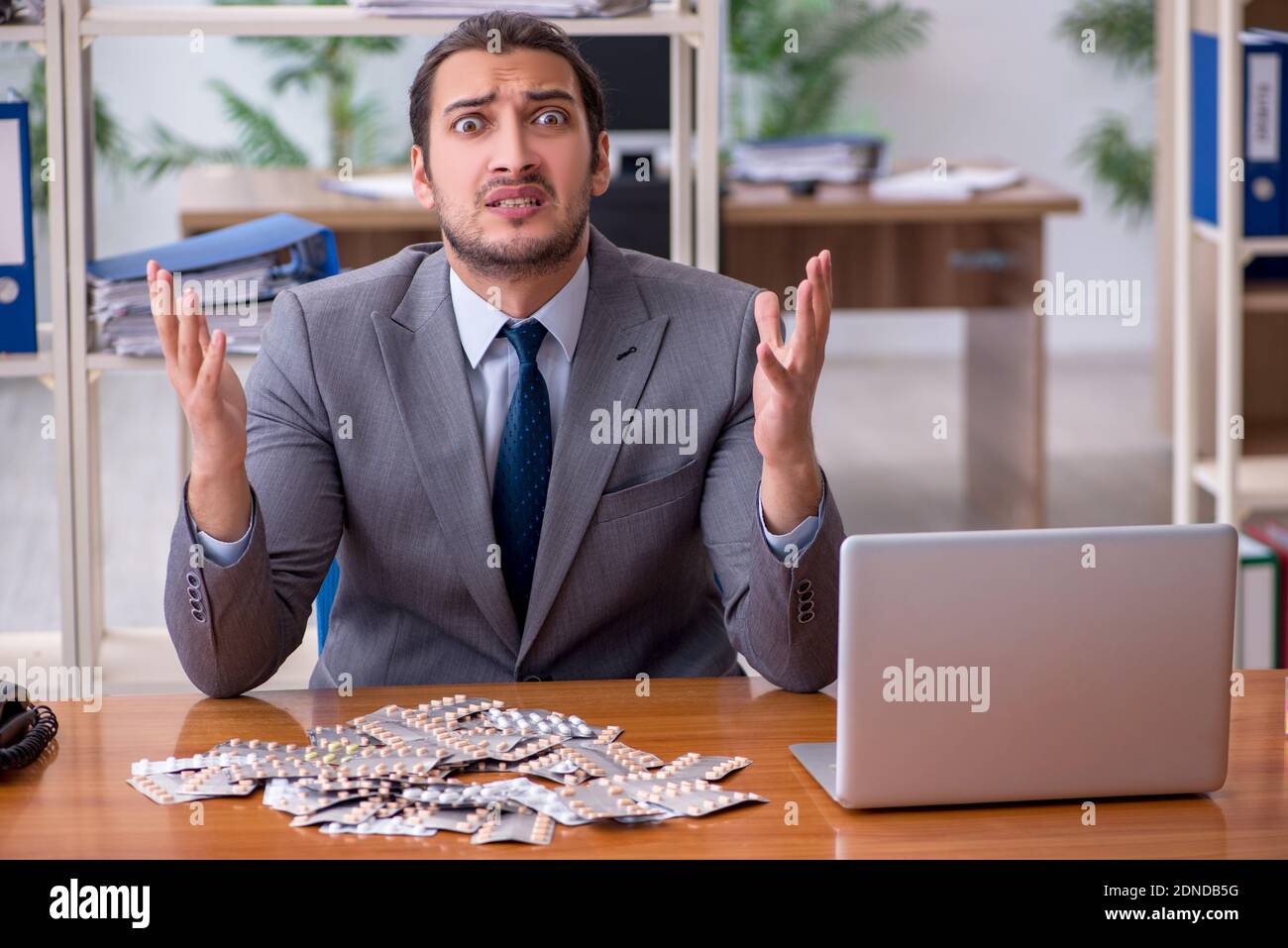 Male sick employee suffering at workplace Stock Photo - Alamy