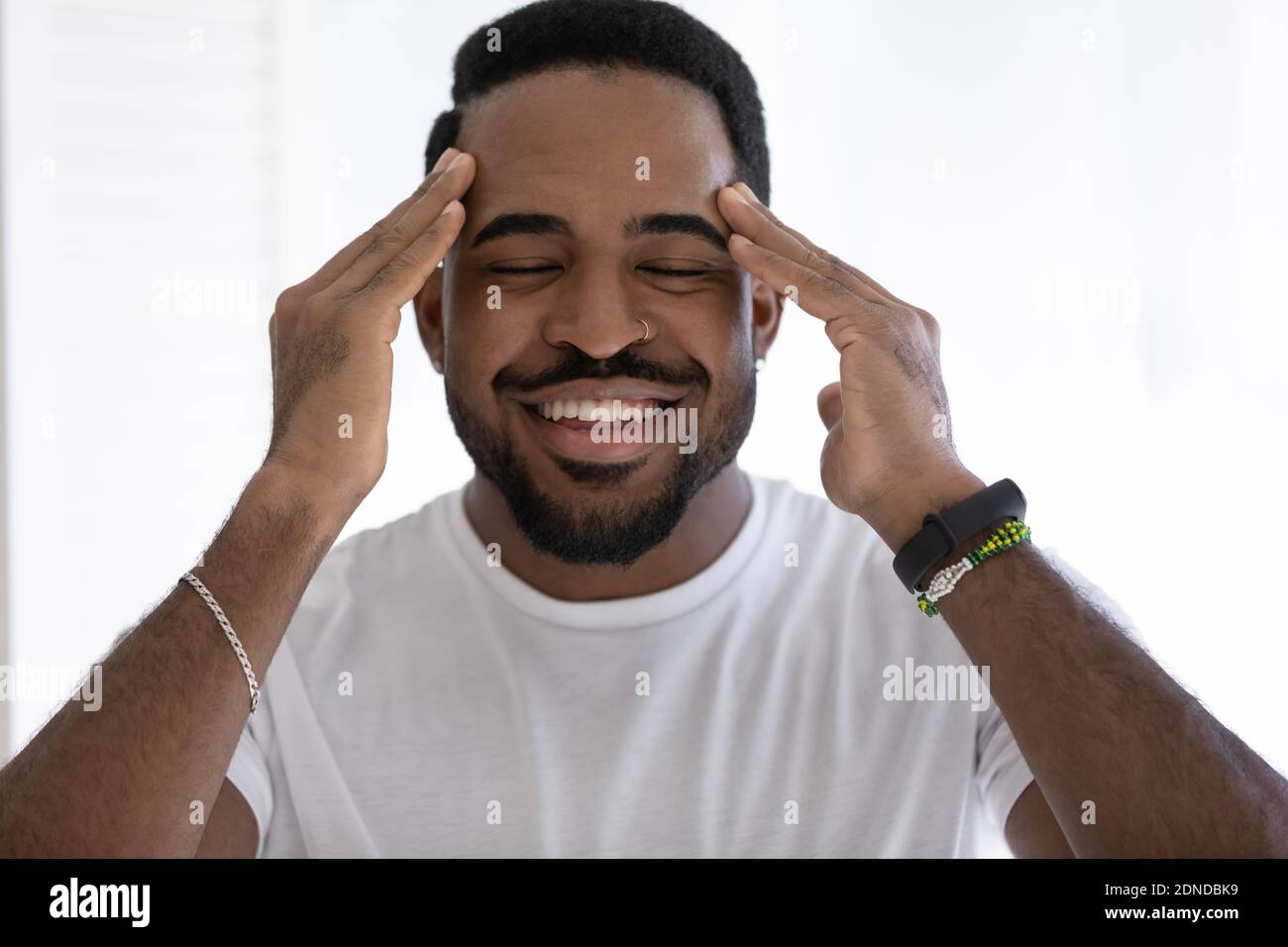 Happy mixed race african man doing relaxing facial massage Stock Photo ...