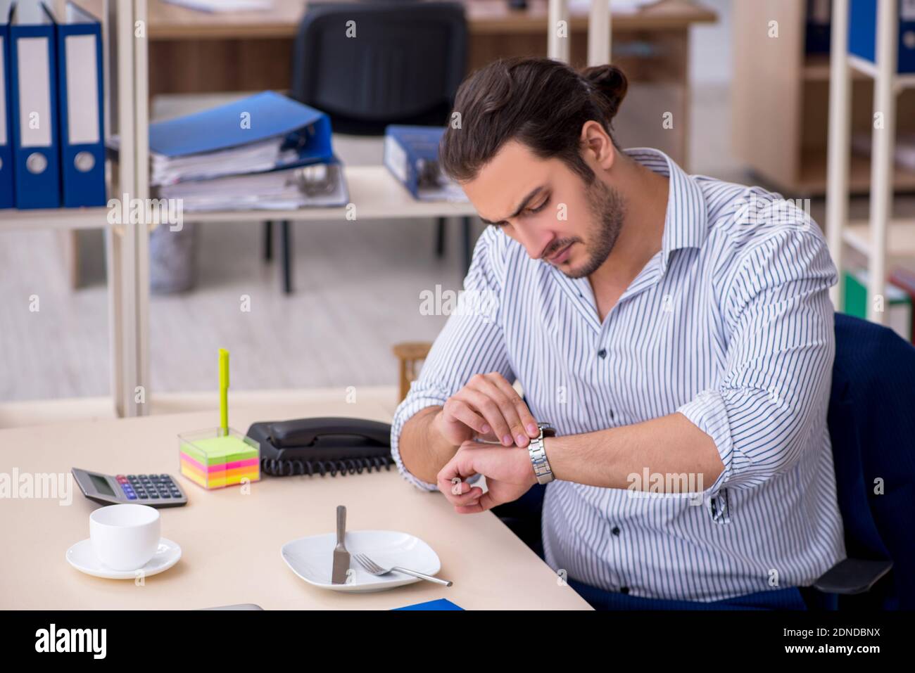 Hungry employee waiting for food in time management concept Stock Photo ...