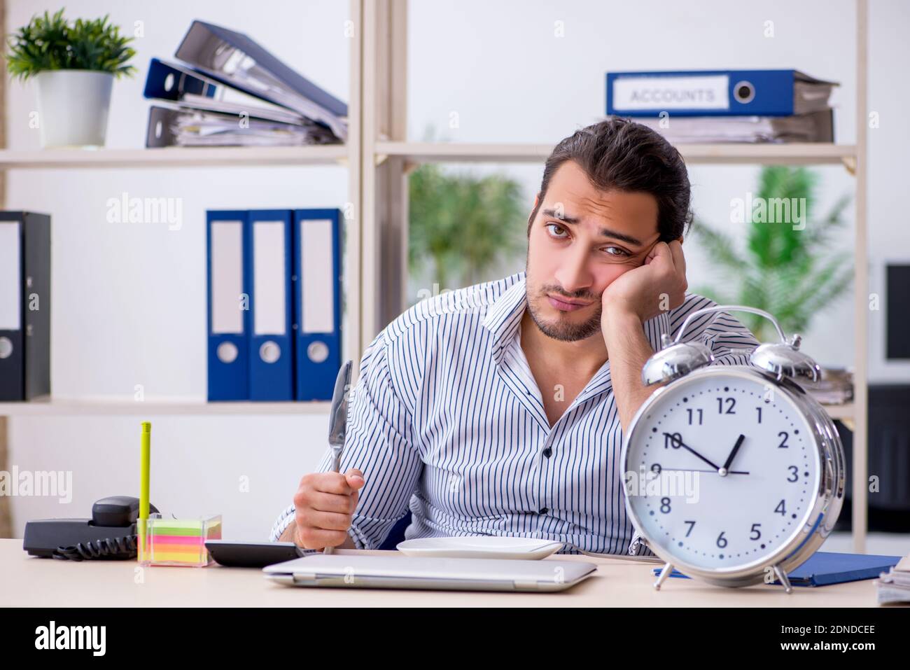 Hungry employee waiting for food in time management concept Stock Photo ...