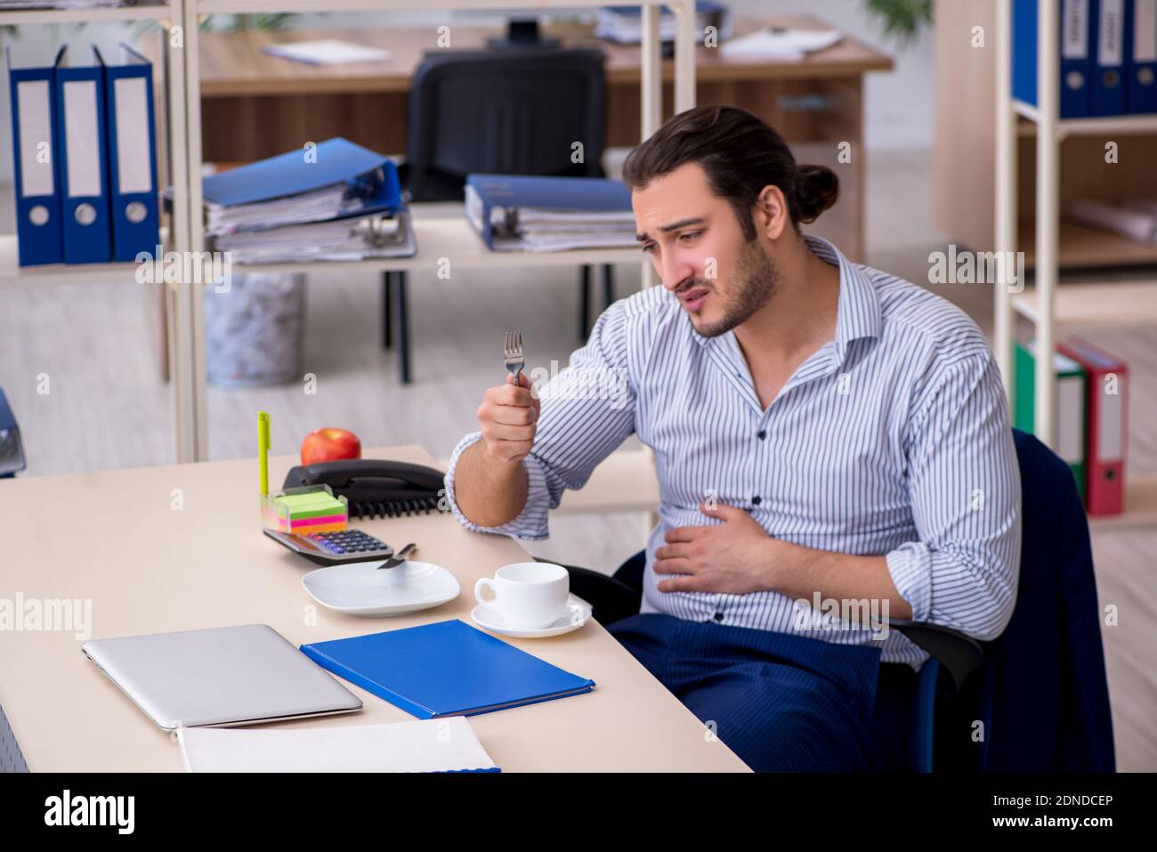 Hungry employee waiting for food at workplace Stock Photo - Alamy