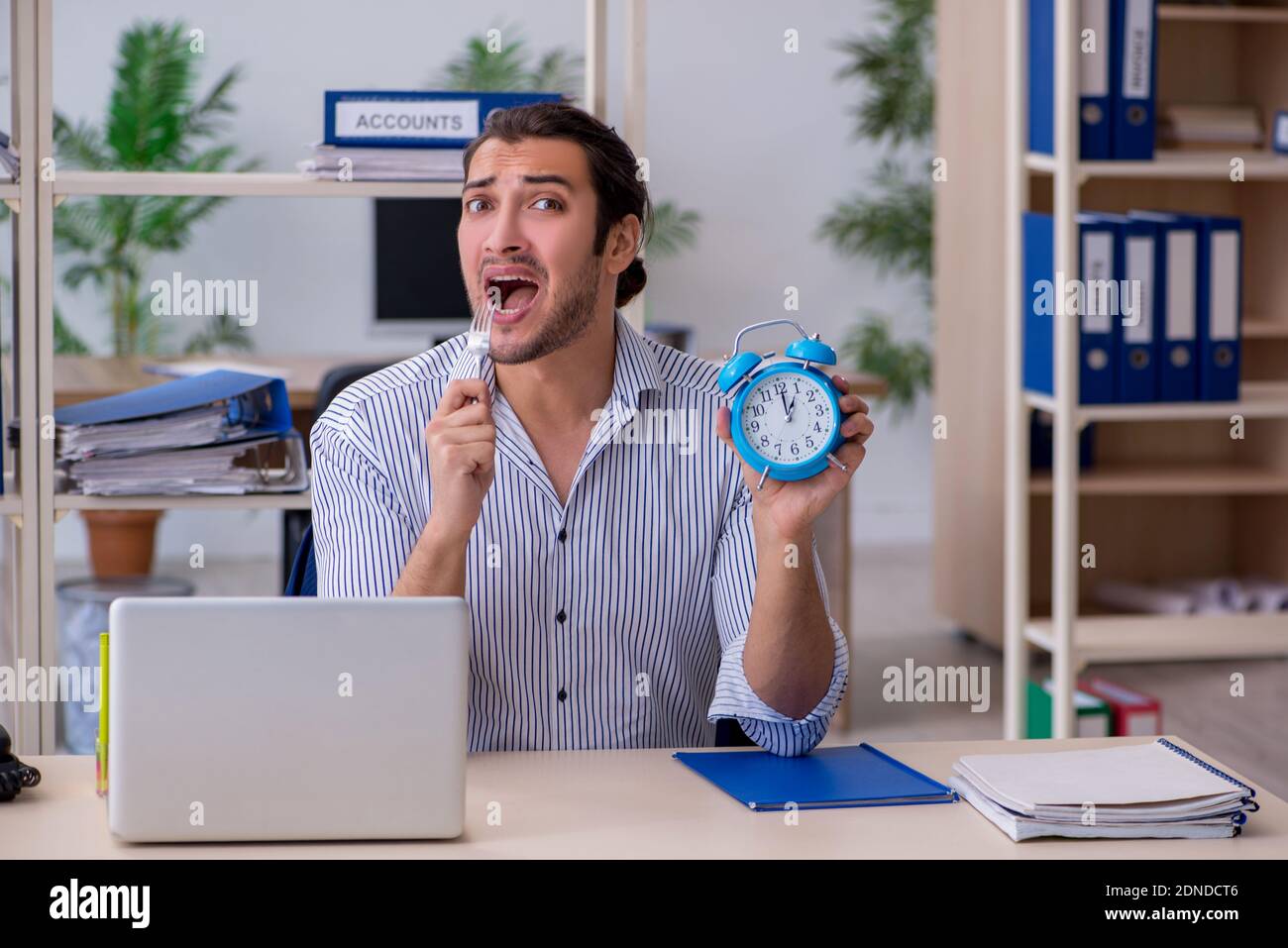 Hungry employee waiting for food in time management concept Stock Photo ...