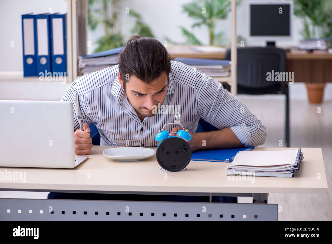 Hungry employee waiting for food in time management concept Stock Photo ...