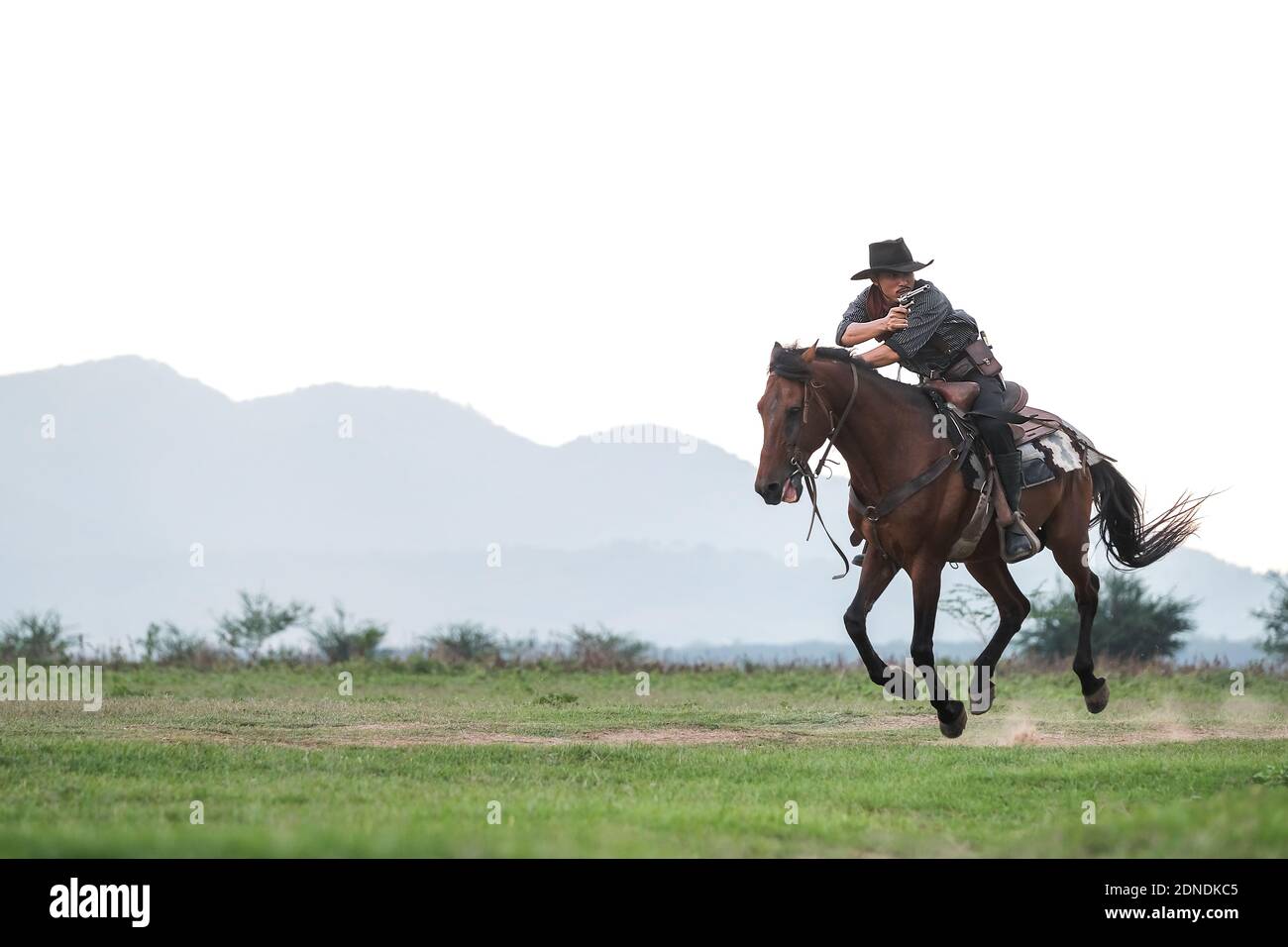 Cowboy riding horse gun hi-res stock photography and images - Alamy