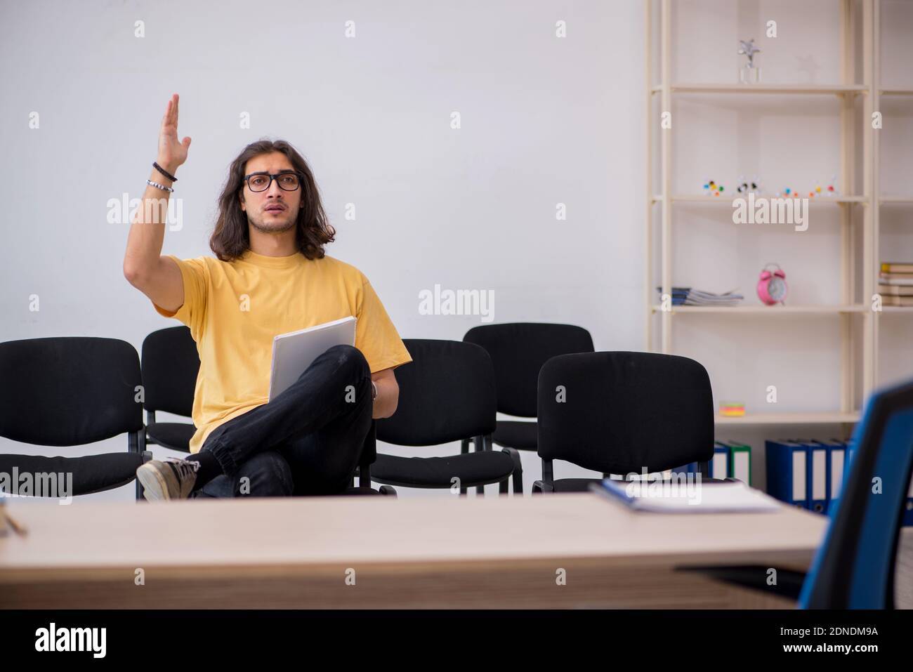 Young student waiting for teacher in the classroom Stock Photo - Alamy