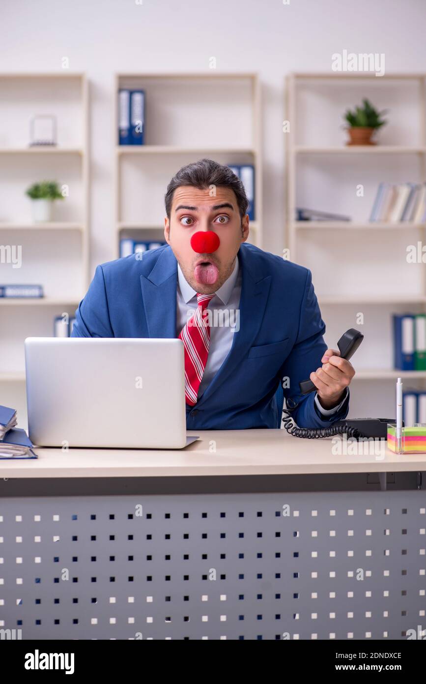 Funny employee clown working in the office room Stock Photo - Alamy