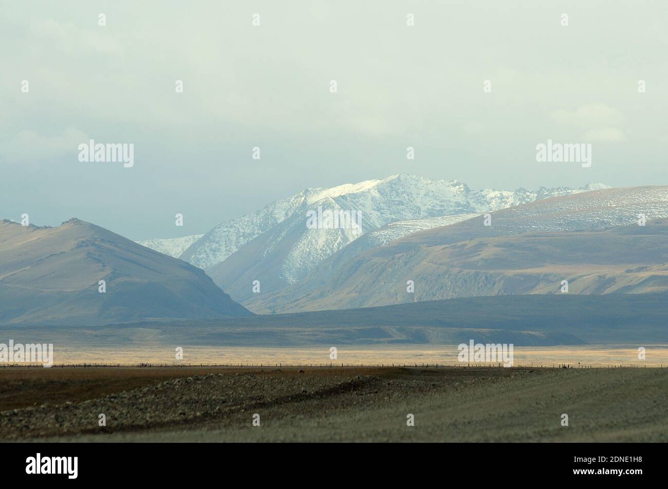 Endless autumn steppe and high snow-capped mountain peaks in the ...