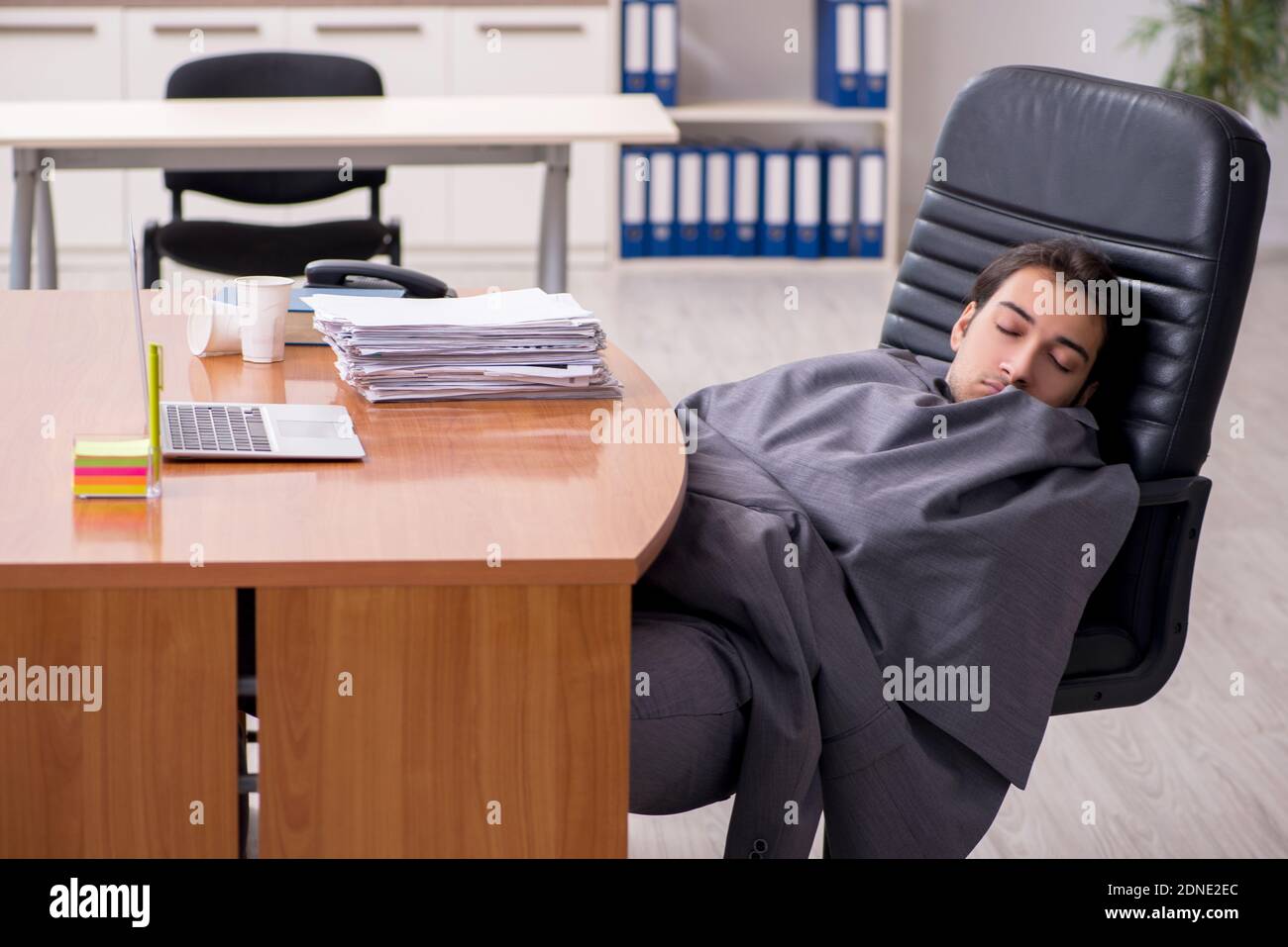 Young employee sleeping in the office Stock Photo - Alamy