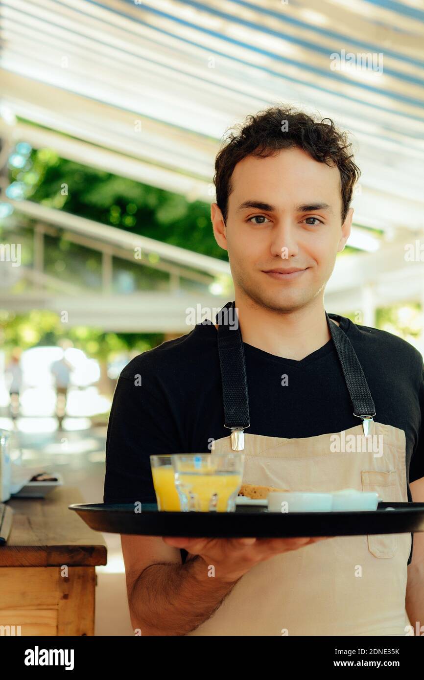 Man in apron serving tray hi-res stock photography and images - Alamy