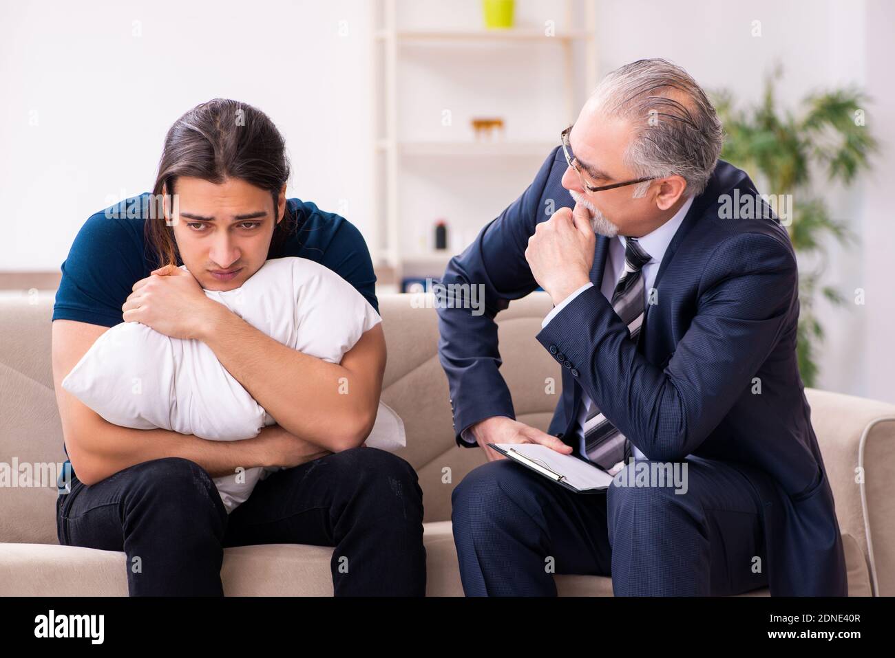 Young man visiting old psychologist Stock Photo - Alamy