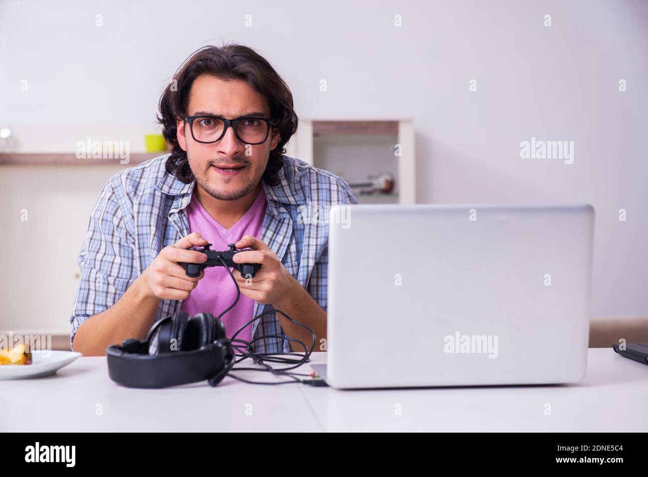 Male student playing computer games at home Stock Photo - Alamy