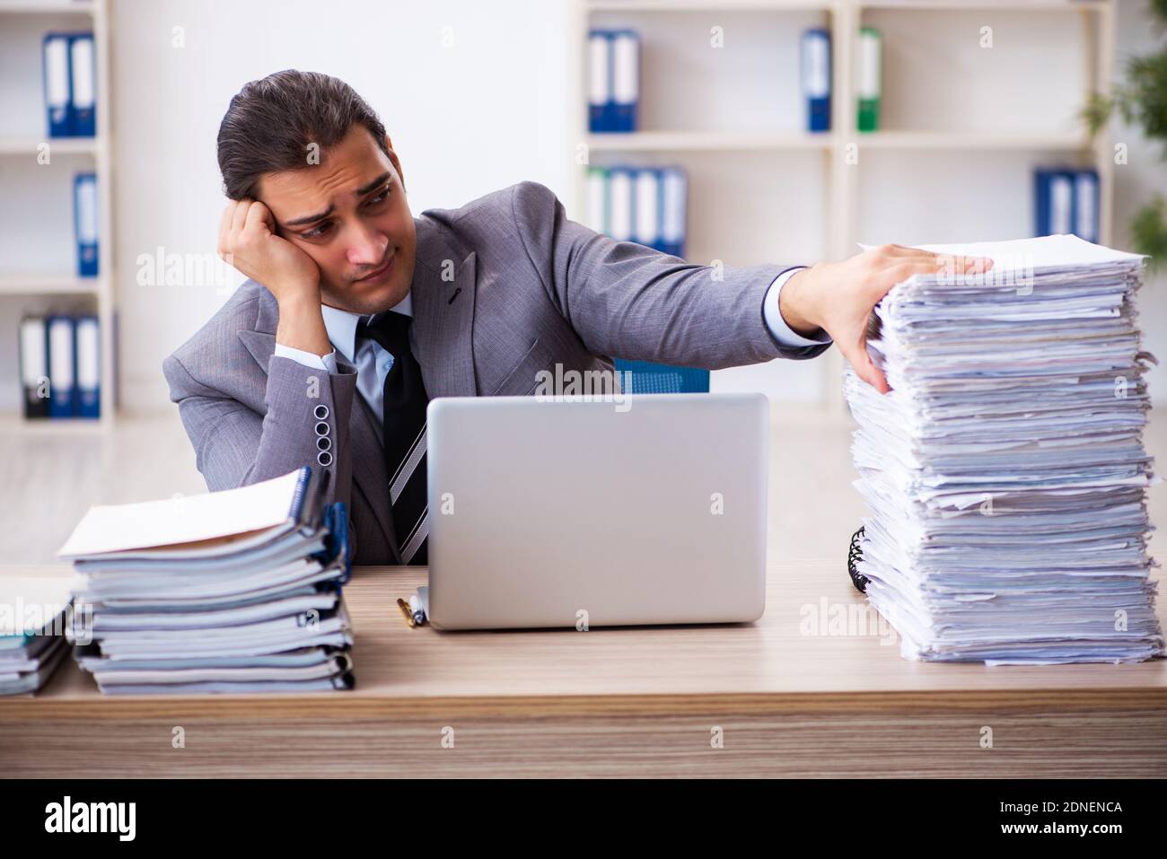 Young employee unhappy with excessive work Stock Photo - Alamy