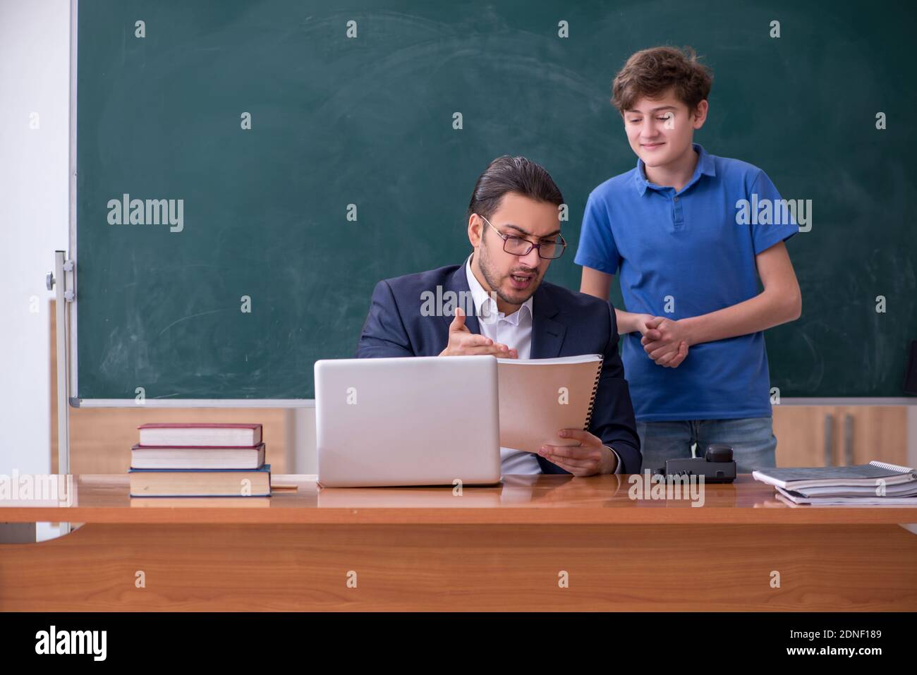 Male teacher and schoolboy in the classroom Stock Photo - Alamy