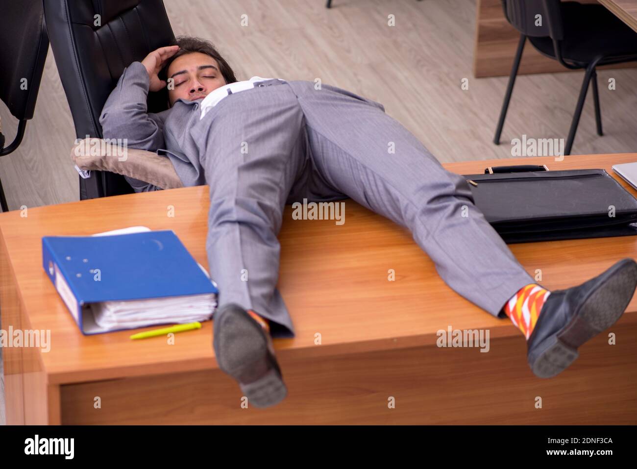 Young employee sleeping at workplace Stock Photo - Alamy