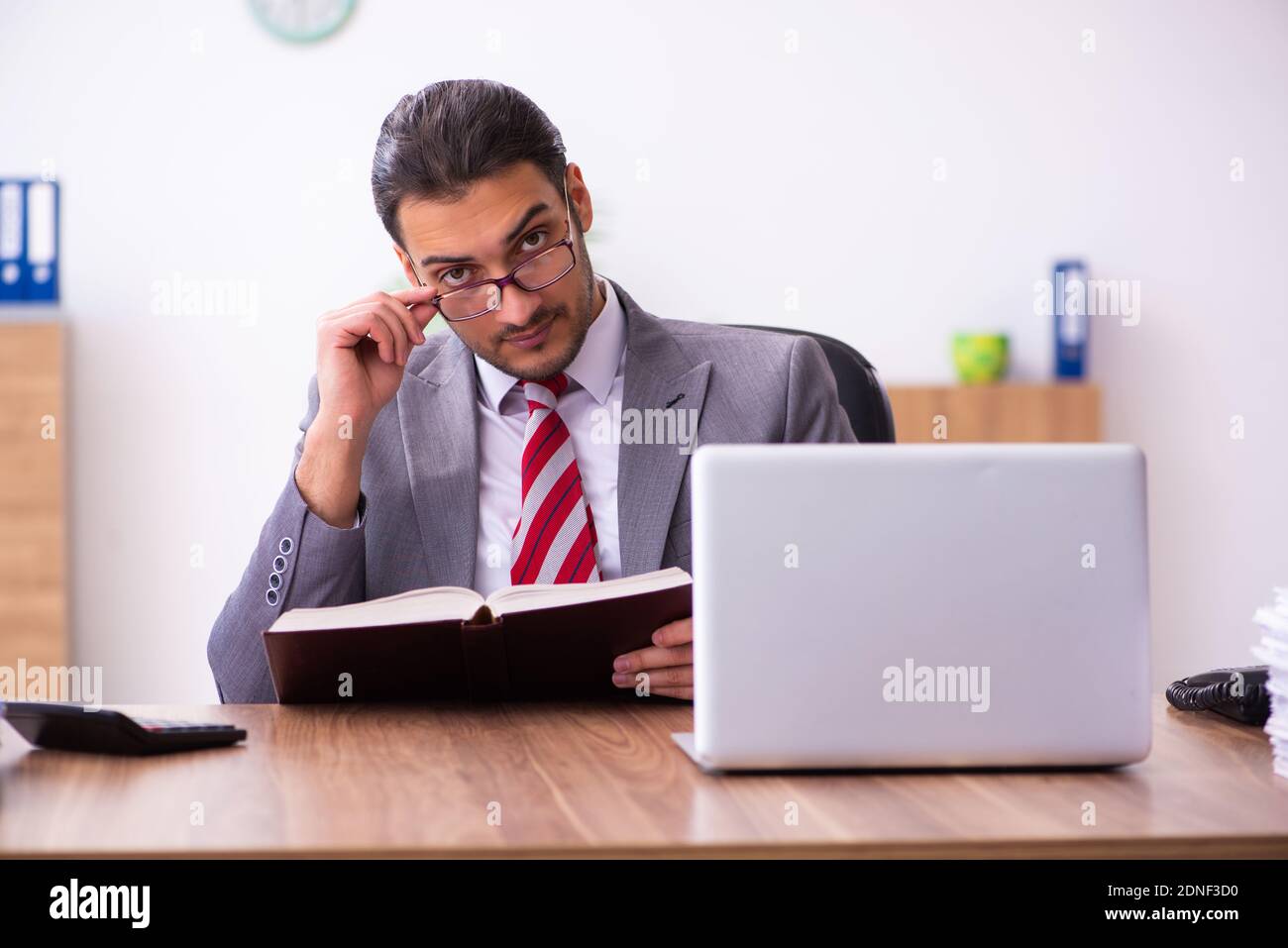 Male employee reading book in the office Stock Photo - Alamy
