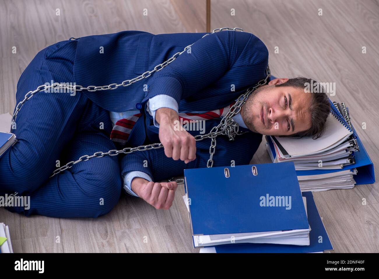 Chained employee unhappy with excessive work in the office Stock Photo ...