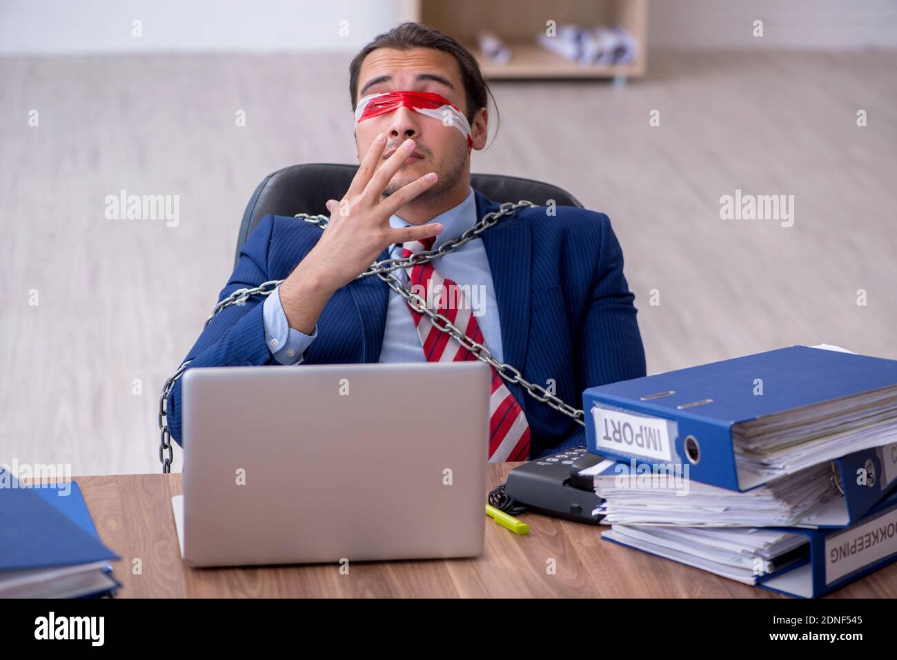 Chained employee unhappy with excessive work in the office Stock Photo ...