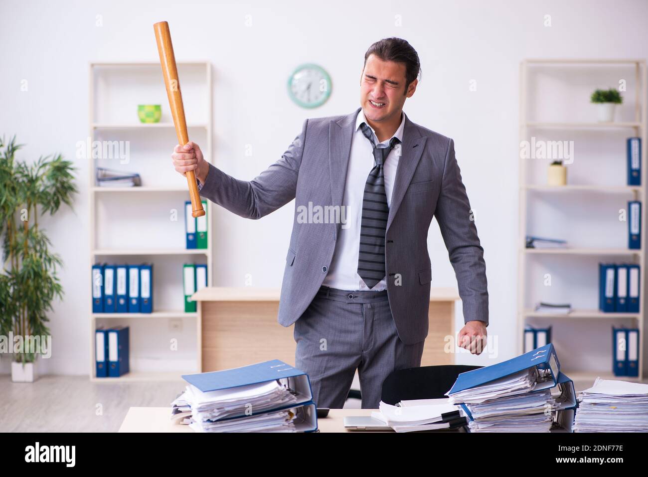Male employee angry with excessive work holding baseball bat Stock ...