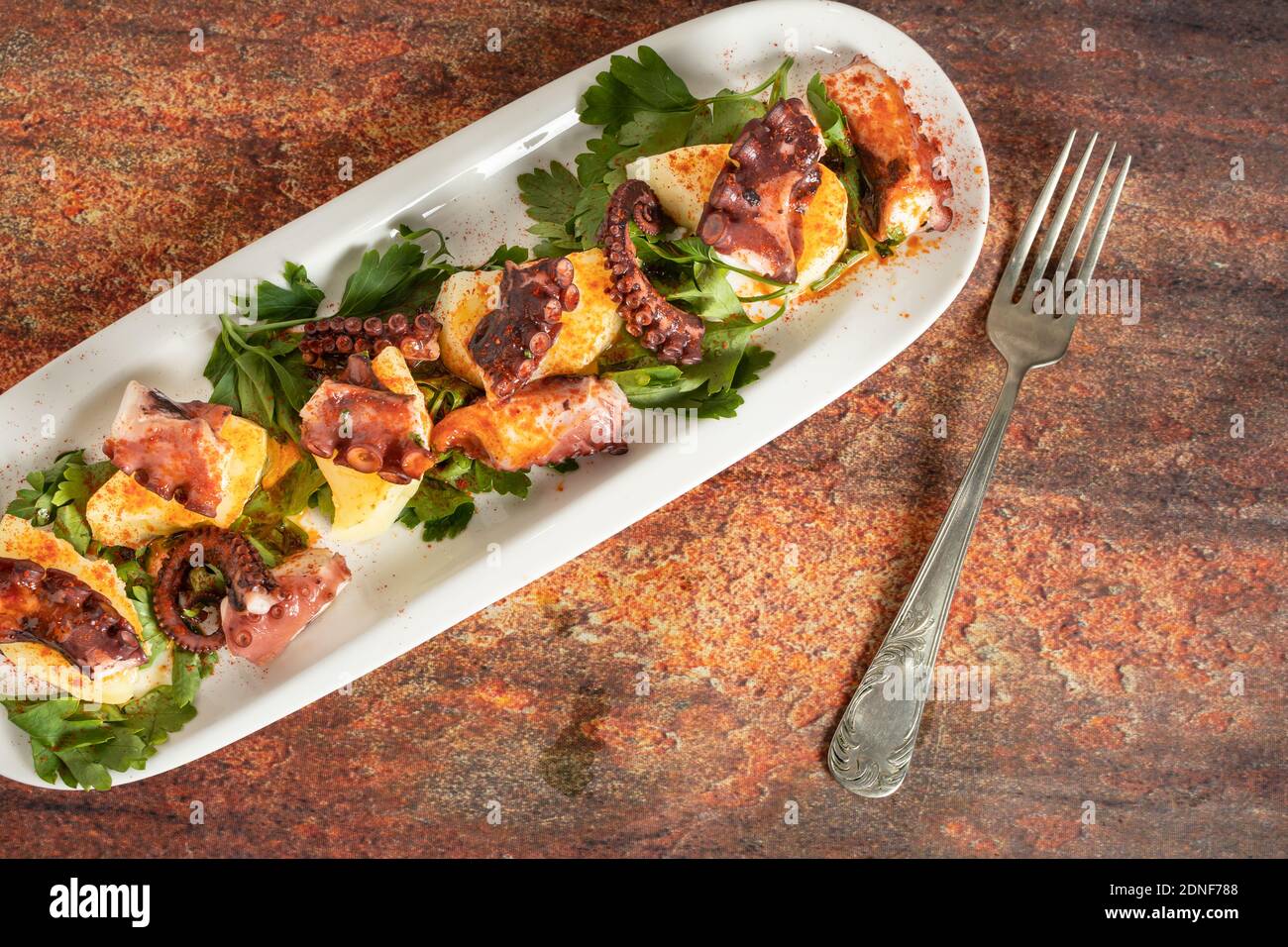 Elongated tray with Galician Octopus, with potatoes, paprika, olive oil ...