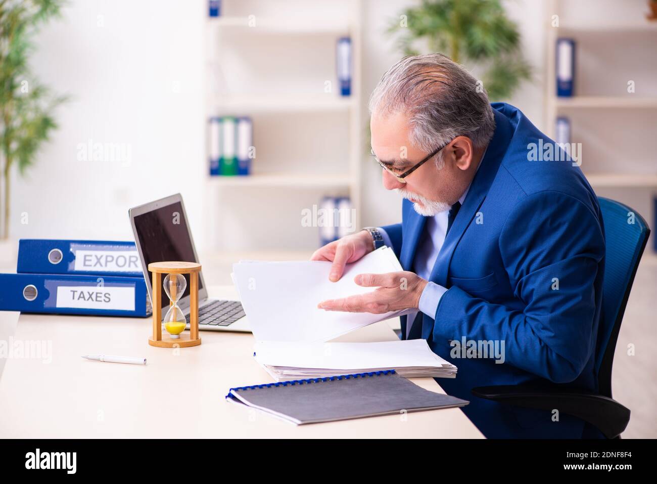 Old employee businessman in time management concept Stock Photo - Alamy