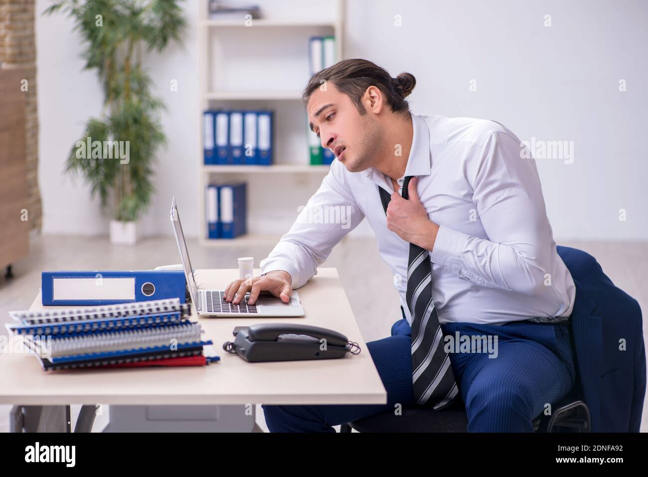 Male employee suffering at workplace Stock Photo - Alamy
