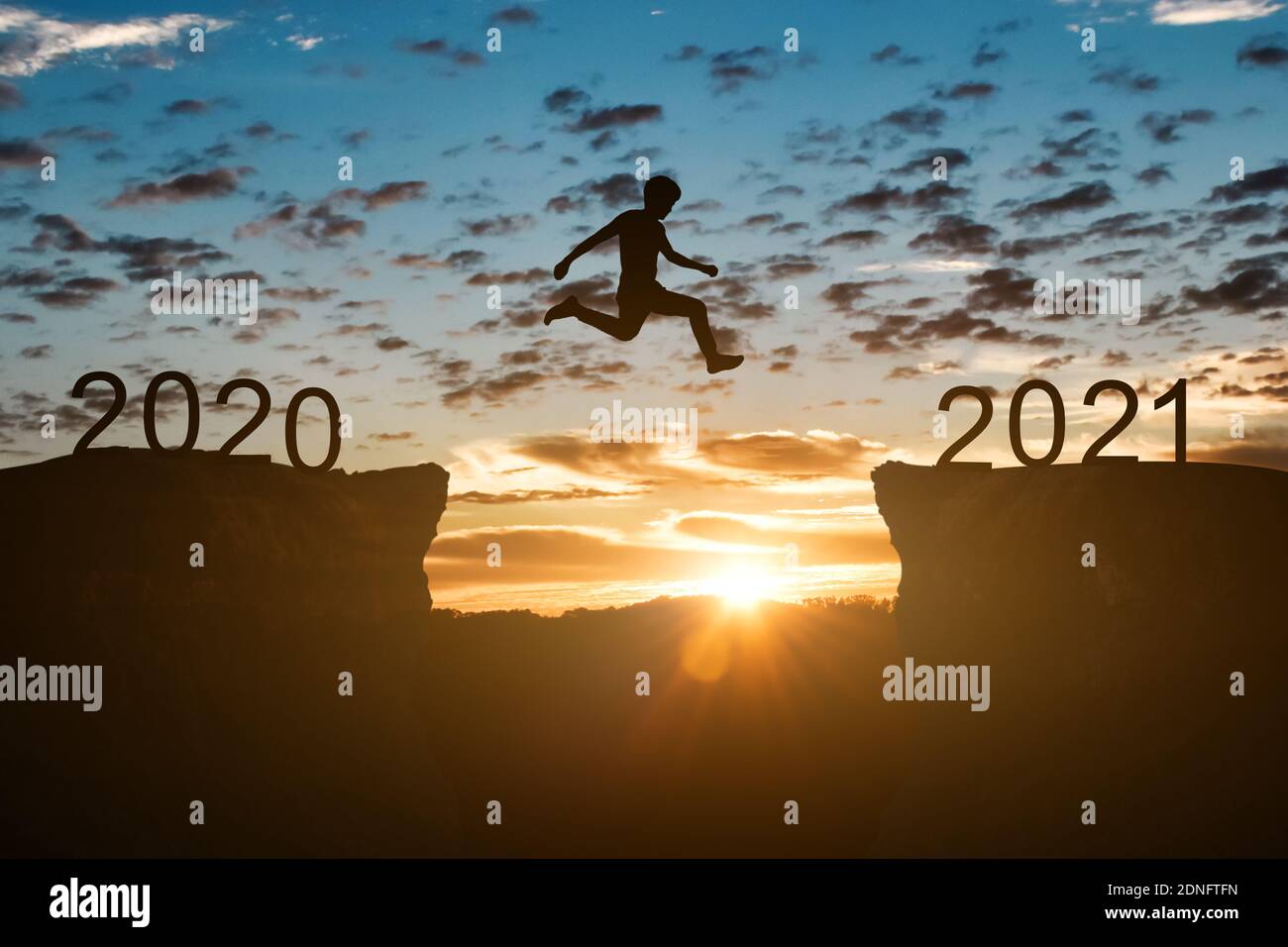 Happy new year 2021 concept. Silhouette of man jump on the cliff ...
