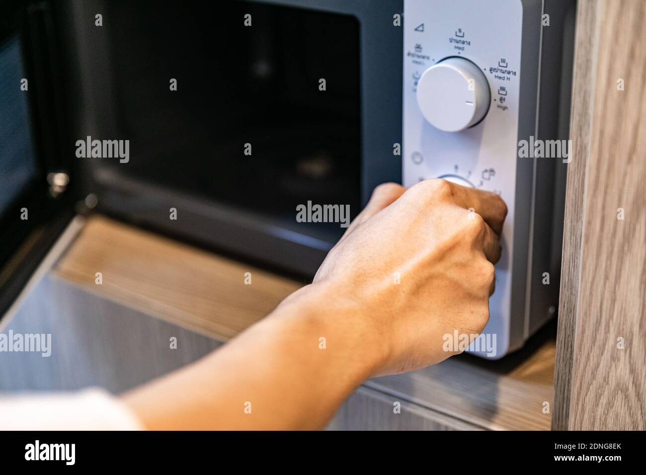 Woman Using Oven In Home Stock Photo - Alamy