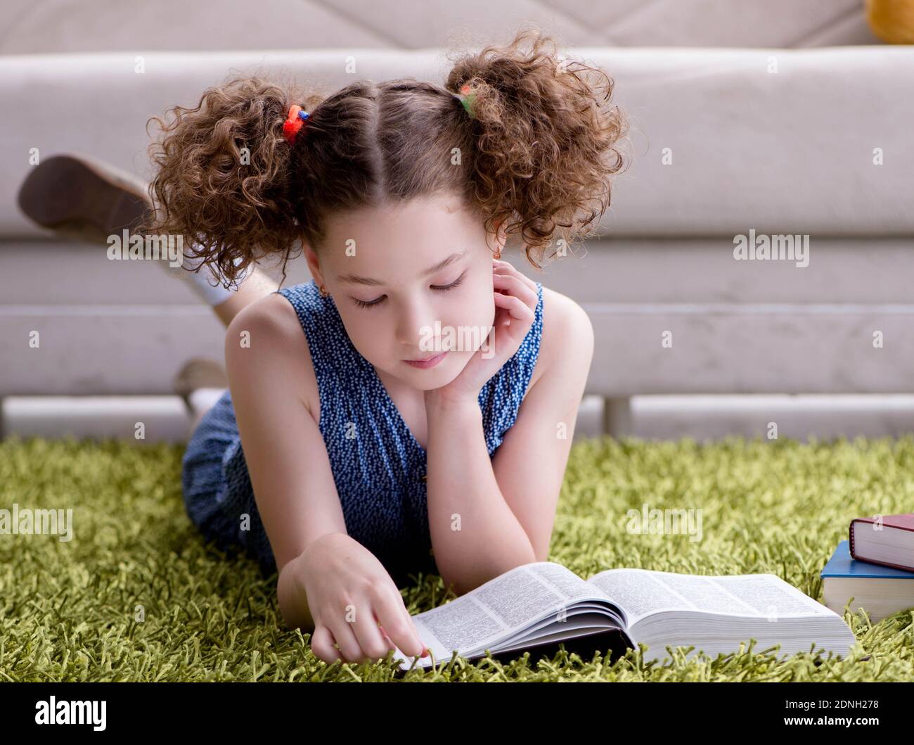 Small girl reading books at home Stock Photo - Alamy