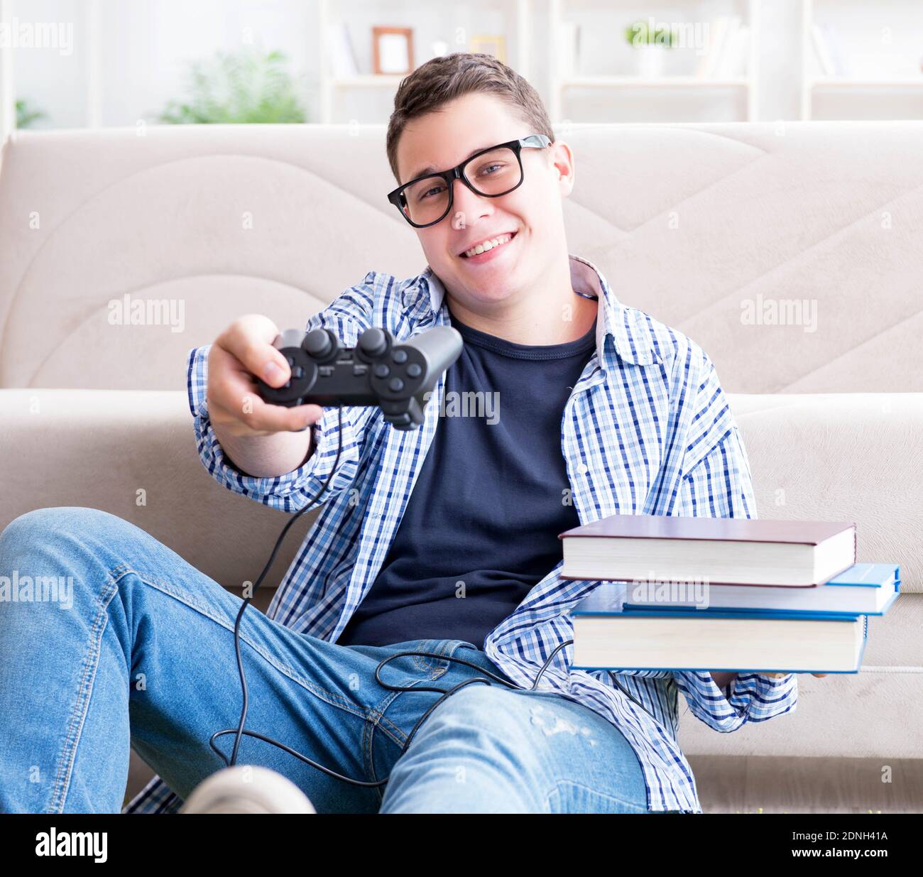 The young student trying to balance studying and playing games Stock ...