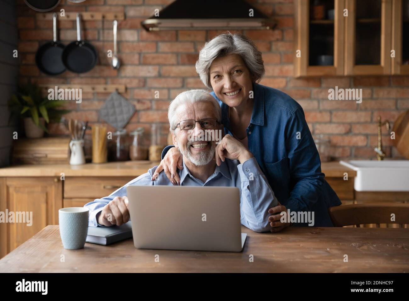 Happy middle aged family couple enjoying using computer applications ...