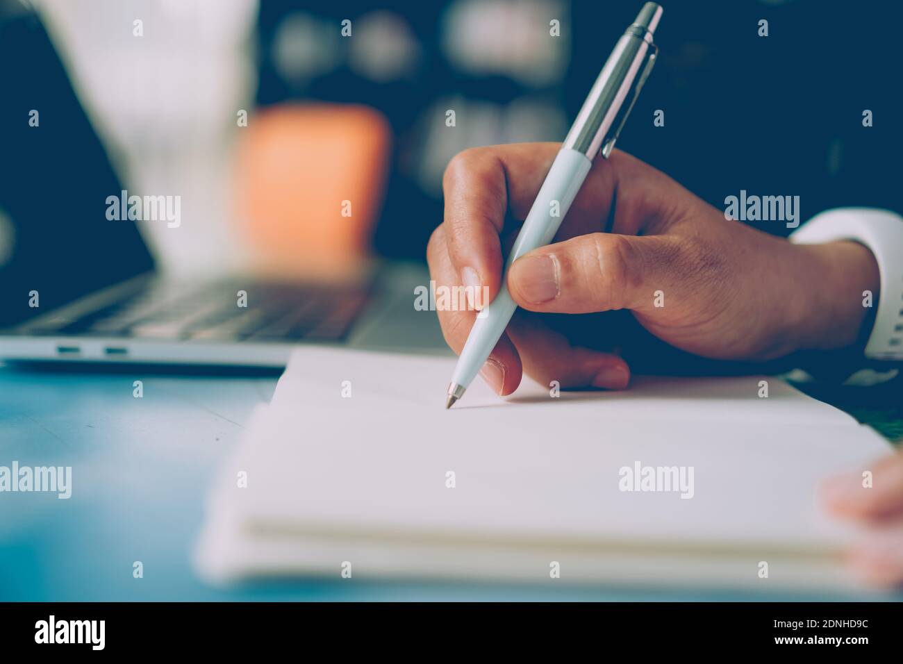 Woman hand writing down in small white memo notebook for take a note ...