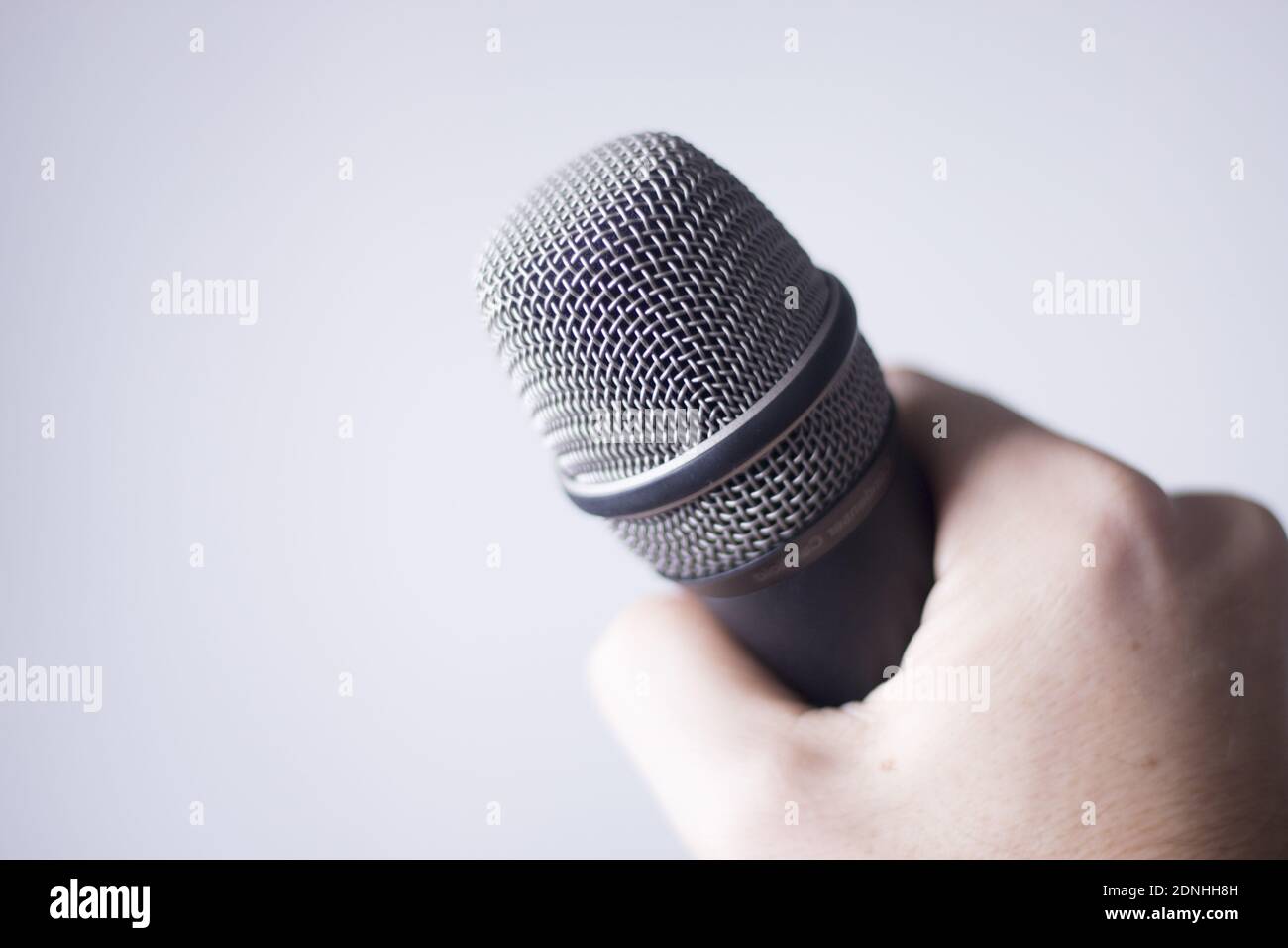 Close-up Of Hand Holding Microphone Against White Background Stock ...