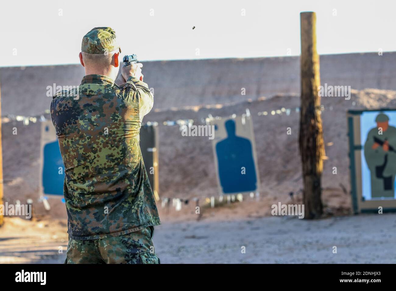 Rear View Of Army Man Shooting With Handgun Against Wall Stock Photo ...