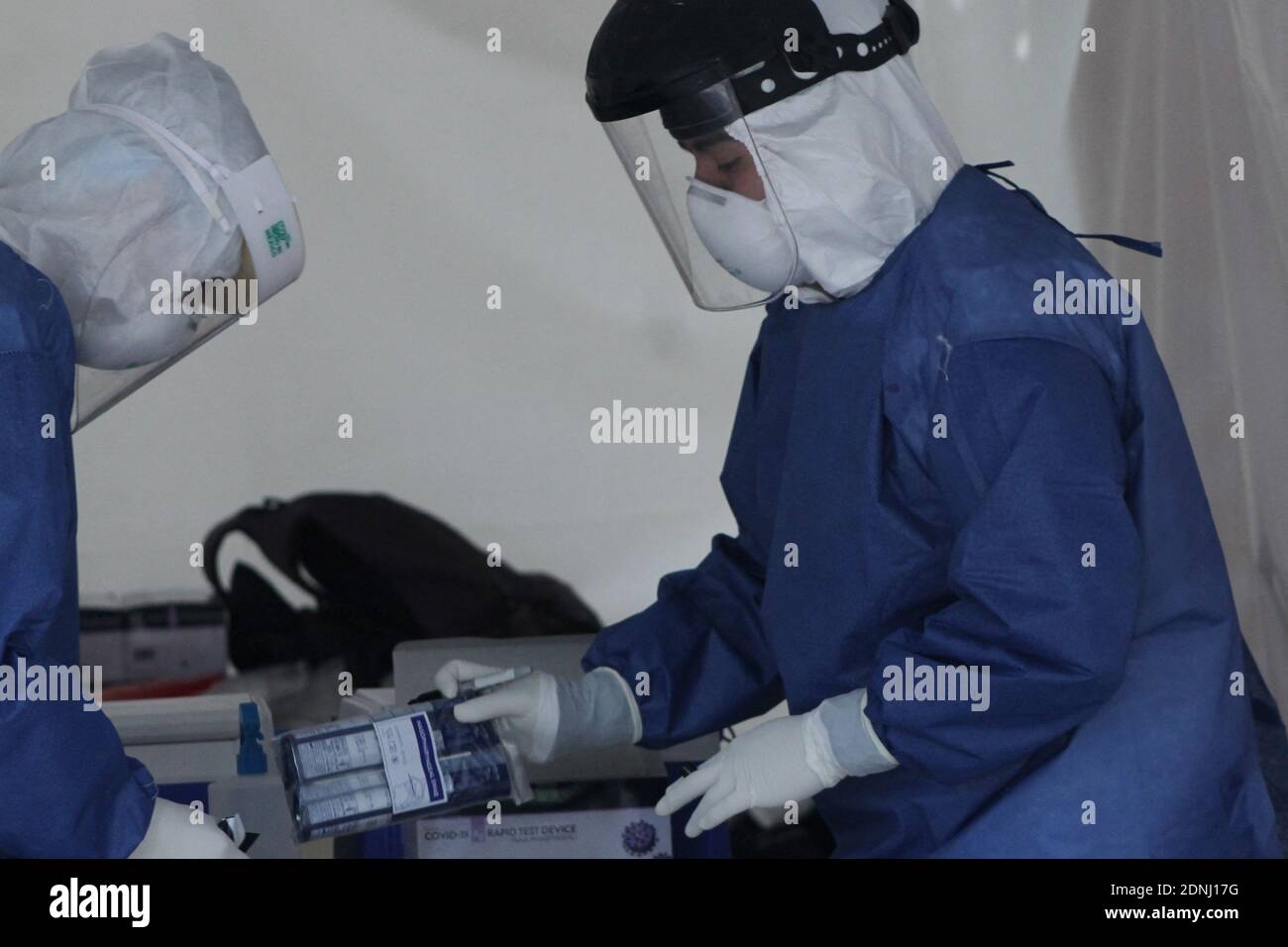 A Specialist weras Personal Protective Equipment (PPE) while makes a ...