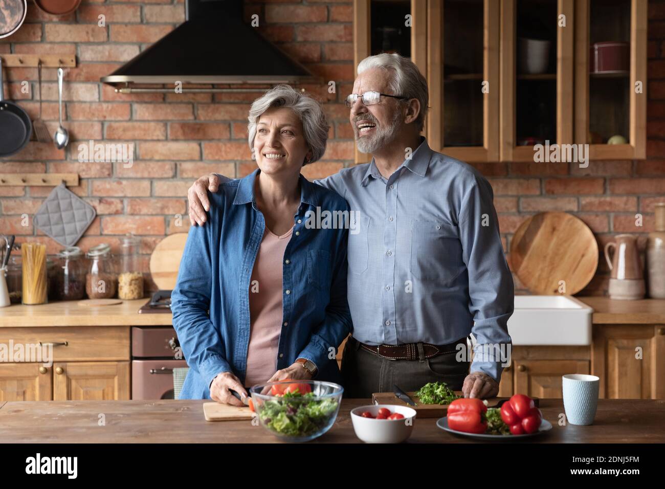 Happy middle aged family couple dreaming, distracted from preparing ...