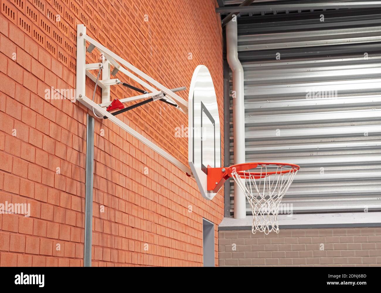 Basket in a school gym, red brick wall Stock Photo - Alamy