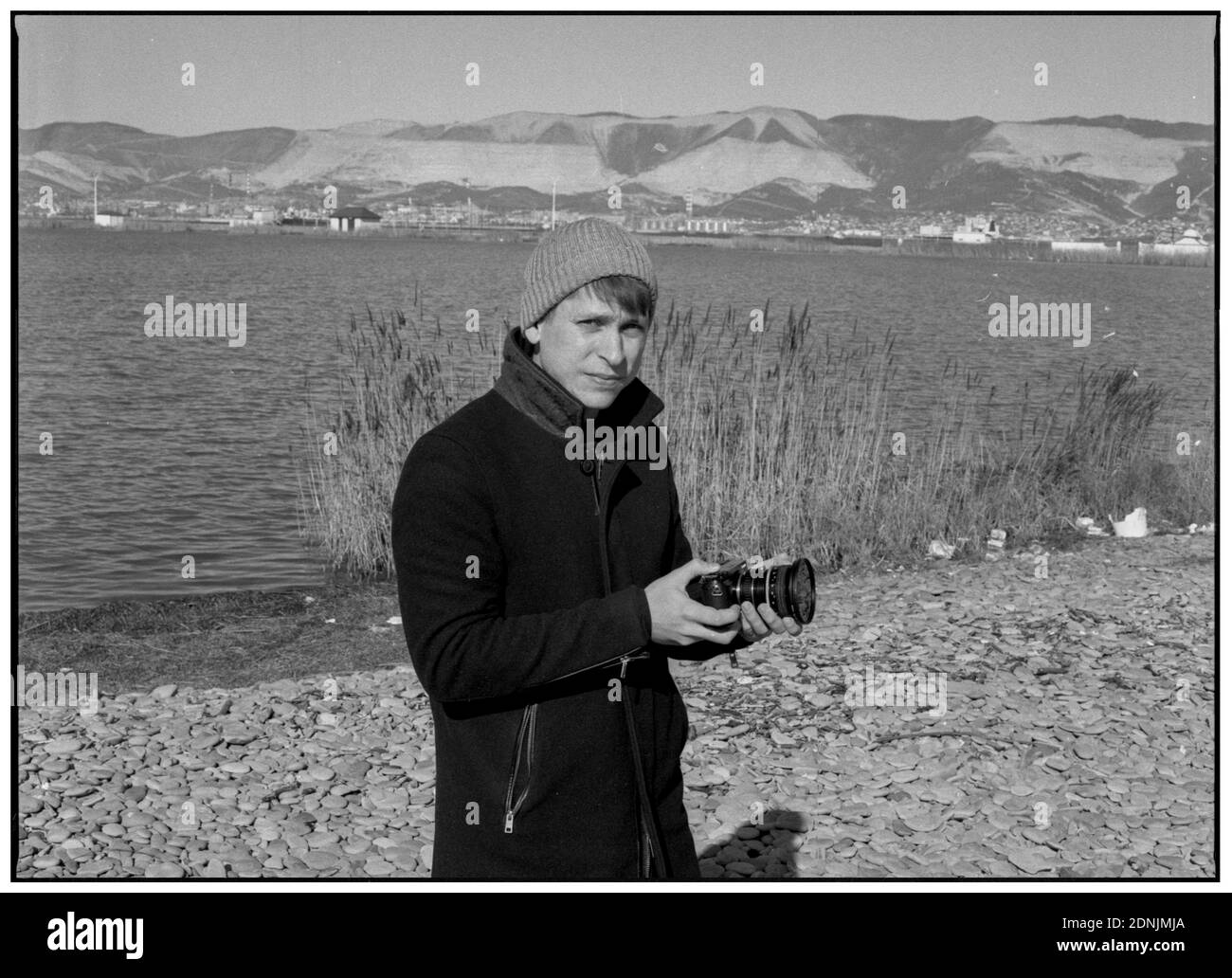 Portrait Of Man Holding Camera While Standing At Beach Stock Photo - Alamy