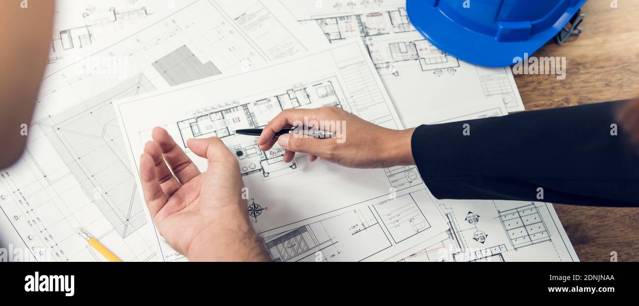 Engineer and architect team discussing floor plan layout at the table ...