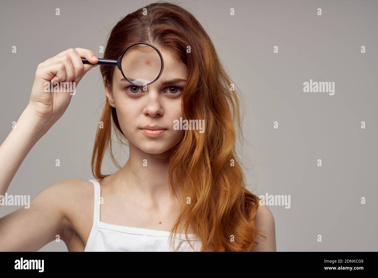 woman with magnifying glass near face acne window health problems ...