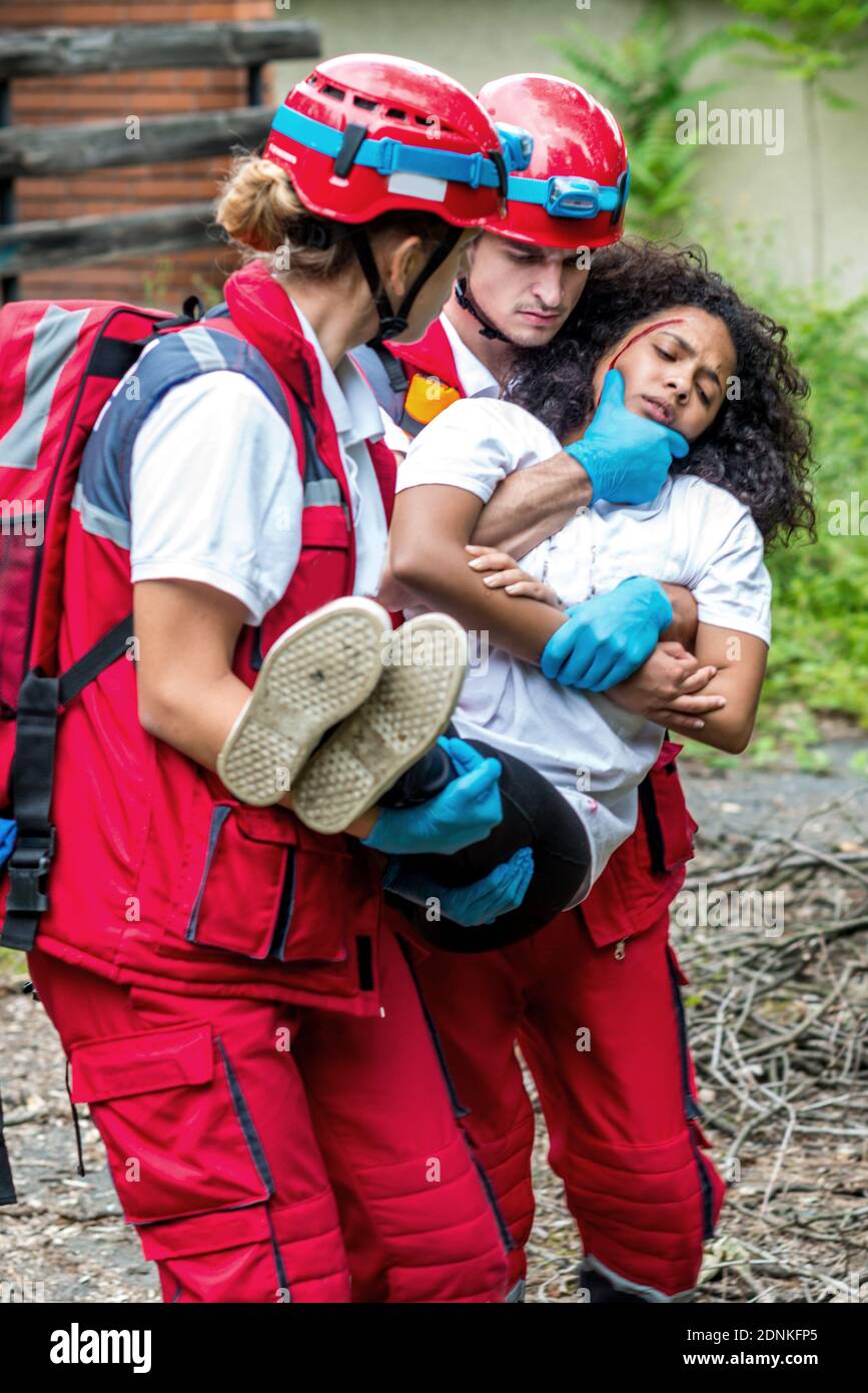 Carrying injured woman hi-res stock photography and images - Alamy
