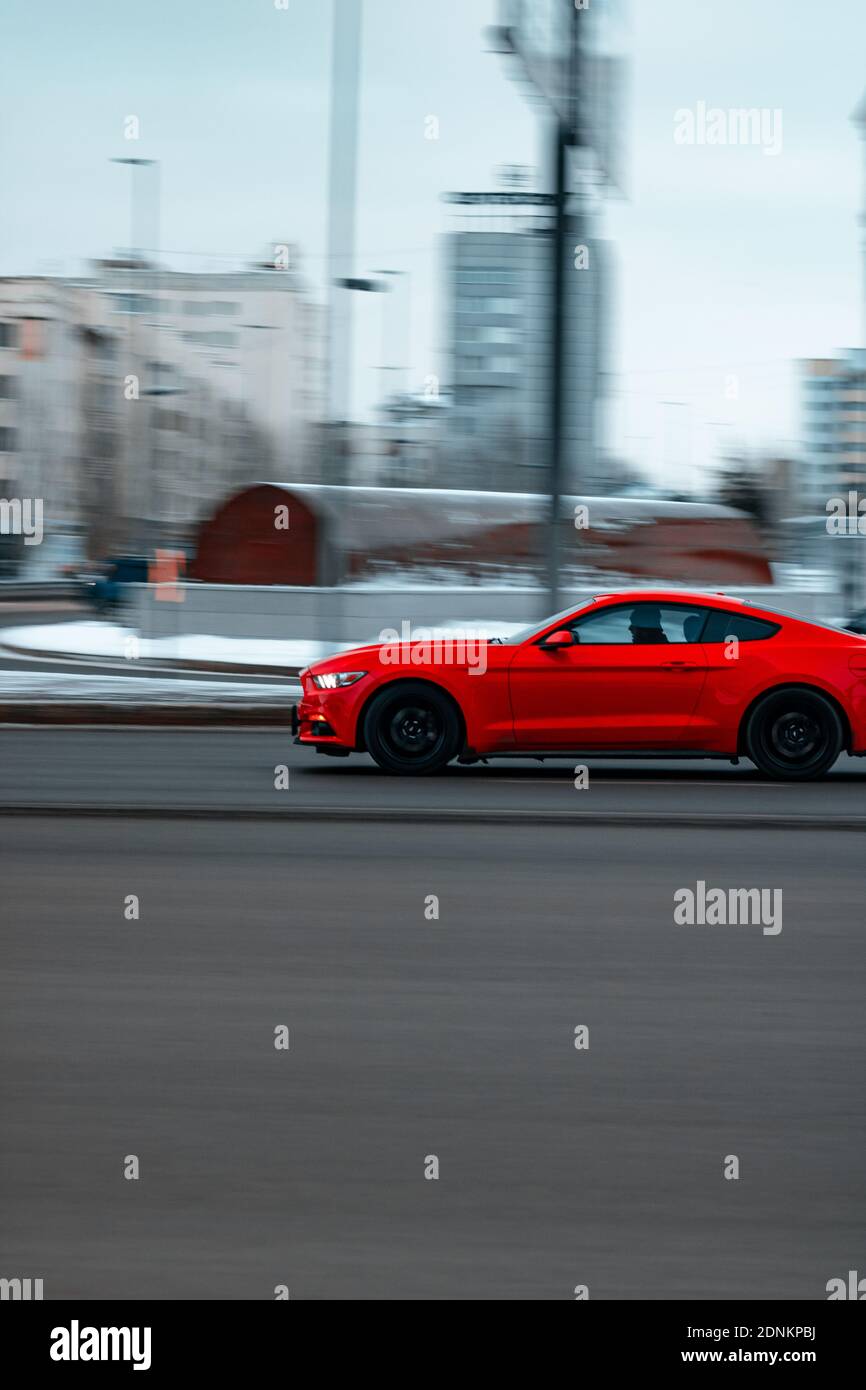 Very fast red car driving in the city Stock Photo - Alamy