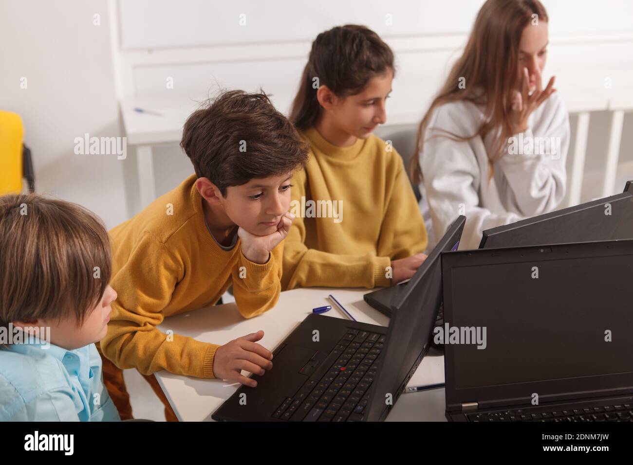 Diverse group of kids working on laptops on computer school lesson ...