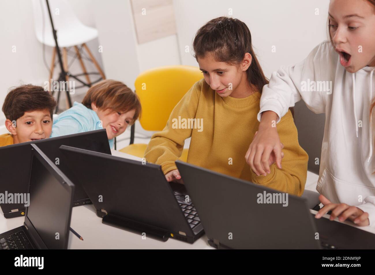 Diverse group of kids having fun, working together on a online project ...