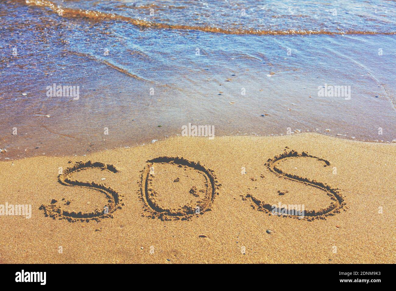 The word SOS on the beach sand Stock Photo - Alamy