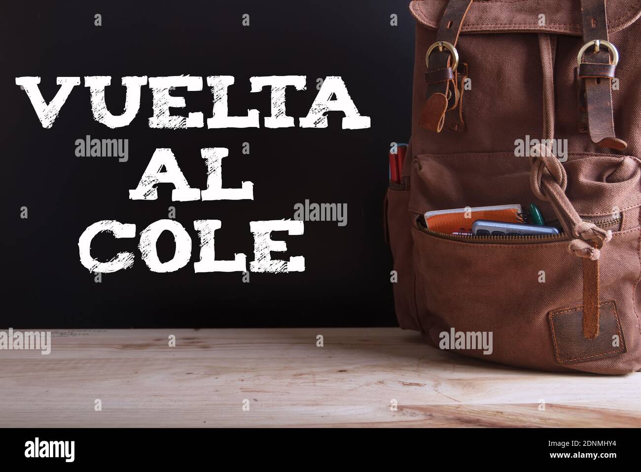 A "Back to school" writing in Spanish and a backpack with notebooks ...